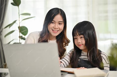 Premium Photo Kind And Happy Asian Sister Helping Her Little Sister