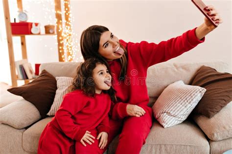 Mother And Daughter Posing With Tongues Out Stylish Mom Taking Selfie