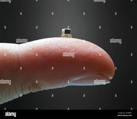 Tiny Microchip On The Fingertip Finger Holding A Miniaturized