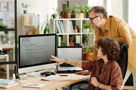 Premium Photo Young Confident Programmer Pointing At Data On Computer
