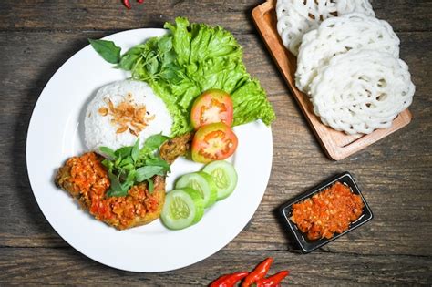Top View Ayam Geprek 인도네시아 음식과 삼발 핫 칠리 소스를 곁들인 흰색 접시에 밥 제공 프리미엄 사진