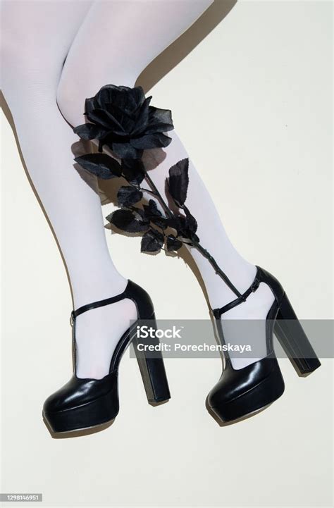 흰색 스타킹과 블랙 레이디 슈즈를 입은 패션 을 알아볼 수 없는 모델 다리 미니멀 한 우아한 파리 세부 사항 플랫 레이 스타일 검은 장미 복고풍 미학 그림자에 대한 스톡