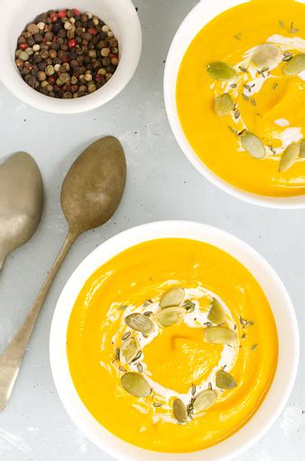 회색 배경의 나무 도마에 말린 씨앗과 백리향 잎을 곁들인 호박 크림 수프 두 그릇 건강한 식생활의 개념 채식주의자 및 비건 음식 상의 View 0명에 대한 스톡 사진 및