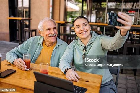 도시의 노천 카페에 앉아 스마트폰으로 셀카를 찍는 할아버지와 시간을 보내는 손녀 20 24세에 대한 스톡 사진 및 기타 이미지 20 24세 2명 70 79세 Istock