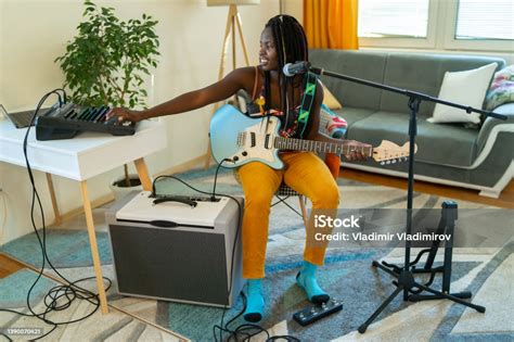 한 젊은 여성이 일렉트릭 기타의 사운드 레벨을 조정하고 있습니다 노래에 대한 스톡 사진 및 기타 이미지 노래 녹음실 음악 Istock