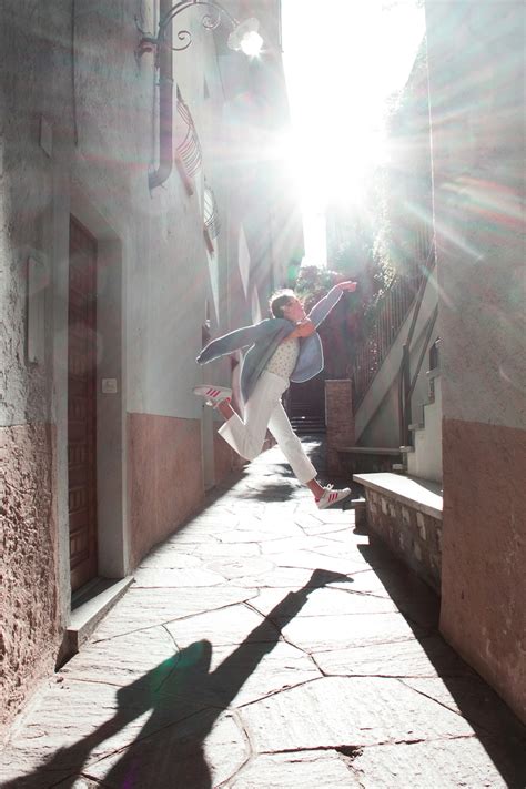 흰색 긴 소매 셔츠와 회색 바지를 입은 여자가 회색 콘크리트 바닥에 서 있다 사진 Unsplash의 무료 플레어 이미지