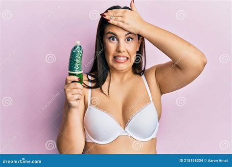 Beautiful Brunette Woman Holding Condom On Cucumber For Sex Education