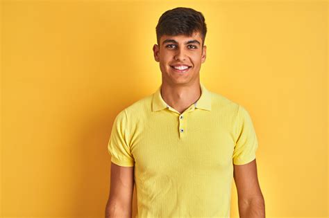 얼굴에 행복하고 시원한 미소와 고립 된 노란색 배경 위에 서 캐주얼 폴로를 입고 젊은 인도 남자 운이 좋은 사람 노랑에 대한 스톡 사진 및 기타 이미지 Istock
