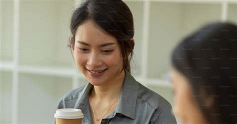 동료가 아이디어를 발표하는 것을 들으면서 웃고 종이컵을 들고 있는 여성 노동자의 초상화 사진 Unsplash의 태국 이미지