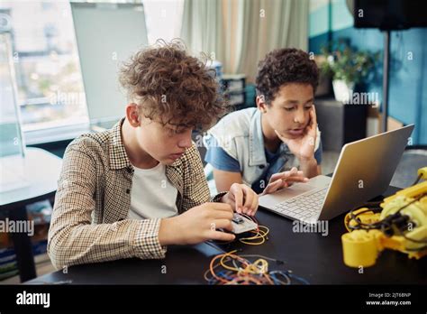 Portrait Of Two Boys Using Laptop Together And Programming Robots
