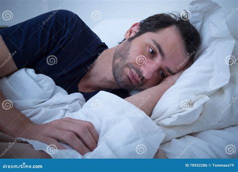 Подавленный человек лежа в его кровати Стоковое Фото изображение насчитывающей дом браслетов