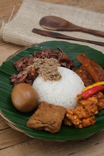 Nasi Gudeg Krecek은 가공된 어린 잭프루트 코코넛 밀크 향신료 두부 계란 및 닭고기로 만든 쌀과 구데그입니다 족자카르타 특산품 인도네시아 음식 바나나 잎과 함께
