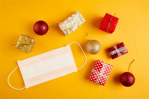 노란 배경에 크리스마스 선물과 장식품이있는 의료 용 얼굴 마스크 코로나바이러스 전염병 중 안전한 크리스마스 축하 파티 0명에 대한 스톡 사진 및 기타 이미지 Istock
