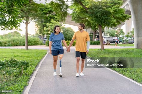 낭만적 인 인종 간 커플 도시 공원을 걷는 손을 함께 잡고 남편과 함께 의족 운동을하는 여성 사람들의 라이프 스타일 활동 가족 관계의 개념 2명에 대한 스톡 사진 및 기타