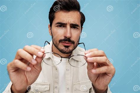 Close Up Portrait Of A Man Looking Through Glasses That He Holds In His