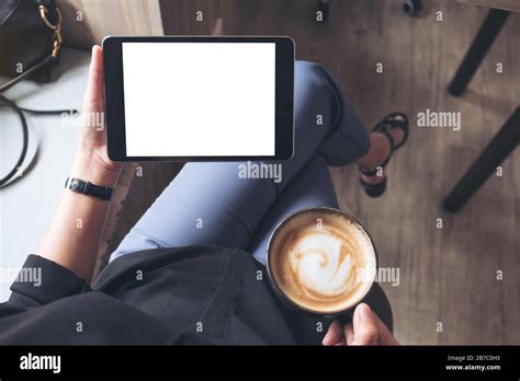 Image Mockup Dune Femme Assise à Pattes Croisées Et Tenant Un Tablet