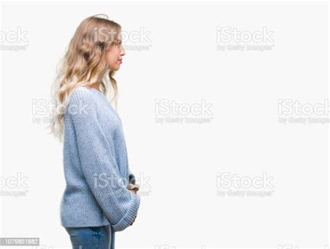 사이드로 보고 격리 된 배경 위에 아름 다운 젊은 금발의 여 자가 입고 겨울 스웨터 긴장 자신감 미소와 자연 스러운 얼굴 프로필 포즈 겨울에 대한 스톡 사진 및 기타 이미지