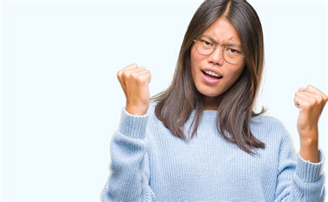 젊은 아시아 여자 매우 행복 하 고 흥분 무기와 우승자 제스처를 하 고 격리 된 배경 위에 겨울 스웨터를 입고 웃 고 성공을 위한 비명 축 하 개념입니다 가을에 대한 스톡