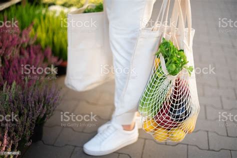 농민 시장에서 비닐 봉지없이 야채와 메쉬 쇼핑 백과 면 구매자를 들고 소녀 제로 폐기물 플라스틱 무료 개념 지속 가능한 라이프
