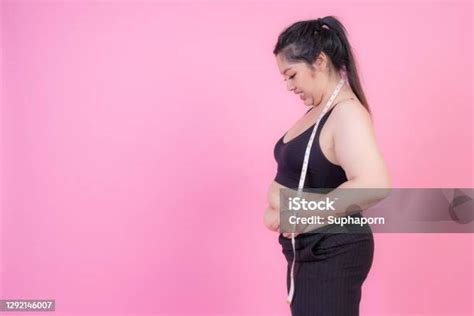 아시아 지방 여성 뚱뚱한 소녀 통통한 핑크 배경에 그녀의 목에 측정 테이프와 과체중 스퀴즈 배꼽 지방 여자 다이어트 라이프 스타일 과체중 문제 개념 25 29세에 대한 스톡