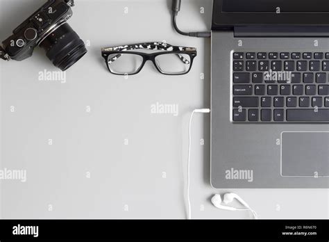 Top View Office Table Concept With Camera Laptop Notebook Glasses And Earphone Smartphone On