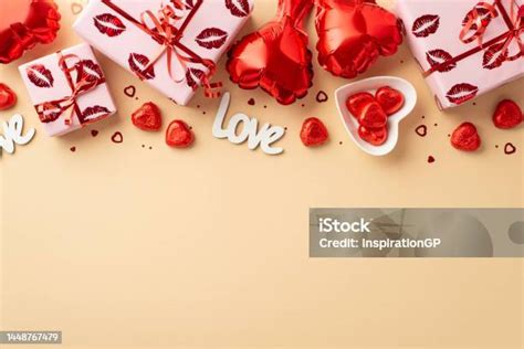 발렌타인 데이 개념입니다 키스 입술 패턴 하트 모양의 풍선 접시 사탕 비문 사랑 색종이 조각과 격리 된 밝은 베이지 색 배경에 복사 공간으로 포장 선물 상자의 상위 뷰 사진