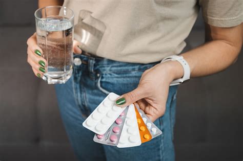 젊은 여자는 약을 들고 치료용 알약과 물 한 잔이 든 다양한 물집 팩 클로즈업 보기 여자에 대한 스톡 사진 및 기타 이미지 여자 감기와 독감 건강관리와 의술 Istock