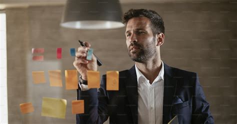 회의실에 있는 사업가 양복을 입은 젊은 사업가가 사업 계획을 세우고 있다 사진 Unsplash의 기업 사업 이미지