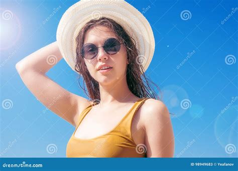 Девушка в солнечных очках и шляпе против моря Стоковое Изображение изображение насчитывающей