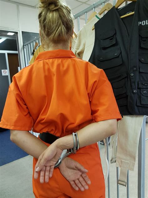 Woman In Prisoner Dress Has Her Hands Cuffed Behind Back With An