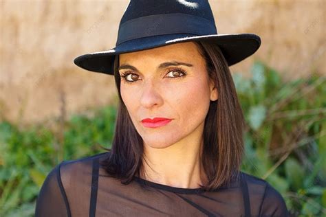 امرأة ناضجة جذابة مع قبعة سوداء وشفتين أحمر في الخارج الخلفية مجلة فوج