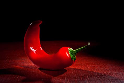고추가 닫힙 칠레 고추 나무 보드에 붉은 배경에 야채 극적인 빛을 예술적 효과로 대조합니다 후추 근처의 텍스트를 위한 공간과 여유 공간을 복사합니다 건강한 식생활에 대한