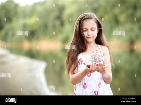Girl Playing With A Toy Sailing Ship By The River Stock Photo Alamy