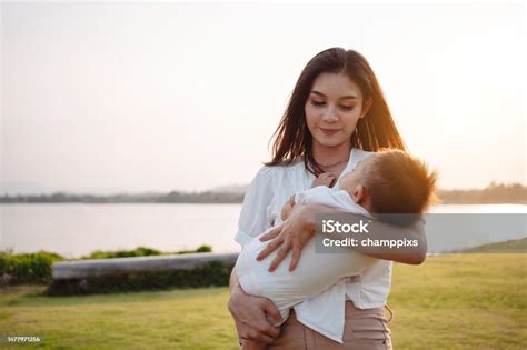 어머니 육아와 신생아 출산 생활 엄마와 아기는 공원 일몰에서 놀고 가족은 함께 즐거운 시간을 보내고 있습니다 육아 출산 개념 25 29세에 대한 스톡 사진 및 기타 이미지