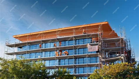 Workers Applying Exterior Cladding And Installing Windows At A Hotel Premium Ai Generated Image