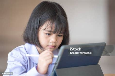 짧은 검은 머리를 가진 유니폼을 입은 동남아시아 여고생이 펜으로 태블릿에 그림을 그린다 교복에 대한 스톡 사진 및 기타 이미지 교복 교육 귀여운 Istock