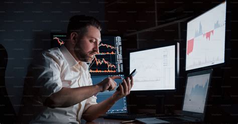 비즈니스 파트너에게 전화합니다 흰 셔츠를 입은 수염 난 남자는 인덱스 차트에 여러 컴퓨터 화면이 있는 사무실에서 일합니다 사진 Unsplash의 우크라이나 이미지