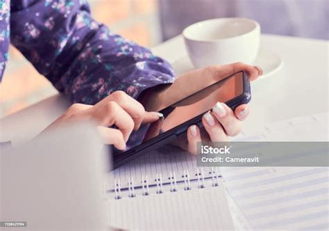 현대 사무실 인테리어에서 컴퓨터에서 작업 하는 동안 스마트 폰을 사용 하 여 여성의 손의 클로즈업 사업가 로프트 인테리어에 그녀의 핸드폰에 문자 메시지를 입력 금융에 대한