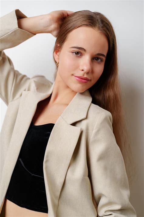 Young Woman Model Posing In Beige Suit Against White Background Stock