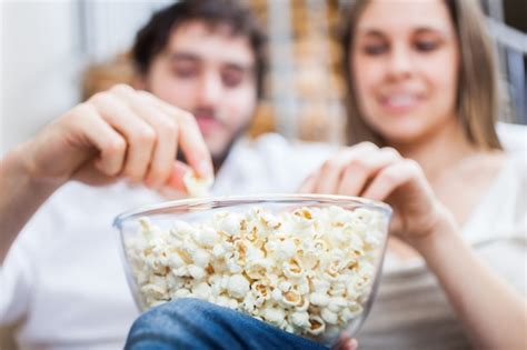 Premium Photo Couple Eating Popcorn While Watching A Movie