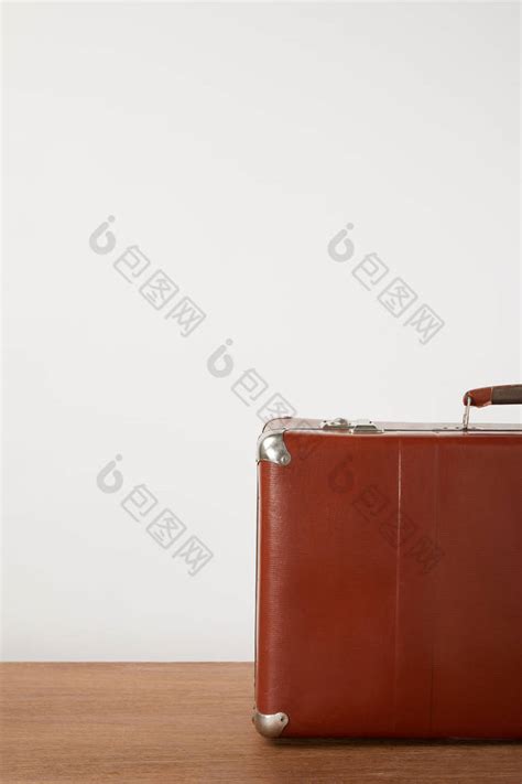 棕色老式手提箱在木桌由白色墙壁图片 包图网企业站