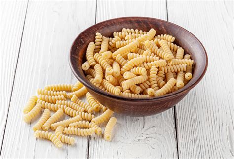 흰색 나무 배경에 세라믹 그릇에 담긴 익히지 않은 푸실리 파스타 코르티기관에 대한 스톡 사진 및 기타 이미지 코르티기관 0명 갈색 Istock