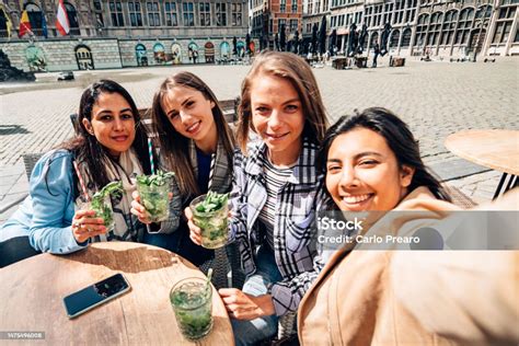 셀카 시간 행복한 네 명의 웃는 여자 친구가 야외에 앉아 칵테일을 마시며 단체 사진을 찍고 있다 인도 왼쪽 여자 얼굴에 선택적 초점 관광객에 대한 스톡 사진 및 기타 이미지