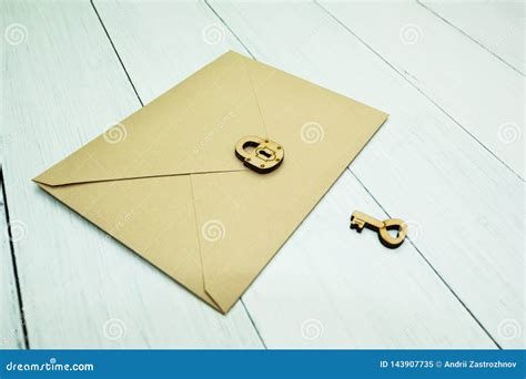 A Paper Mail Envelope Is Closed With A Lock Next To The Key On A White Table A Secret Stock