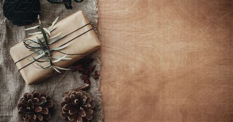 녹색 가지와 전나무 가지 아니스 솔방울 소박한 나무 배경에 계피가 있는 세련되고 소박한 선물 상자 간단한 에코 선물 텍스트를 위한 공간입니다 메리 크리스마스 컨셉