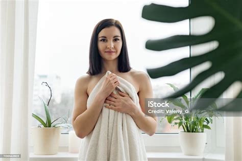 미용 목욕 타 올 스파 집에서 초점 근접 촬영 녹색 잎에 젊은 갈색 머리 여자의 초상화 여자는 창 근처 서 카메라 보고 겨울 봄 시즌 흐린 날 가꿔주기에 대한 스톡 사진 및