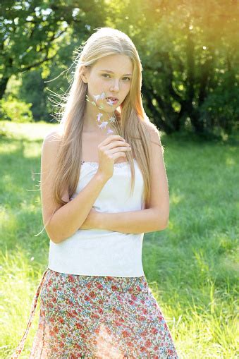 Girl With Blond Long Hair And Blue Eyes Walks In The Garden Dreams