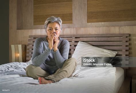 우울 하 고 슬픈 회색 머리 성숙한 여 자가 울고 침대에 앉아 외로운 고통 및 우울증 문제 느낌 손실 및 가정 침실 좌절 하 고 스트레스에 압도 40 49세에 대한 스톡