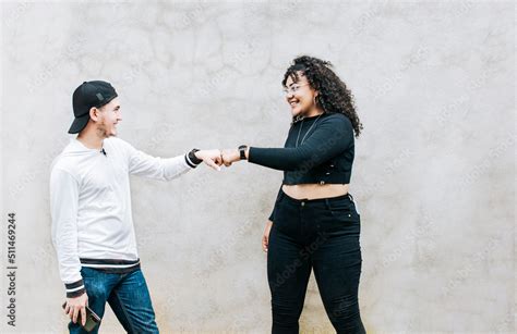 Two Teenage Friends Bumping Their Fists A Guy And Teenage Girl Shaking Fists At Each Other