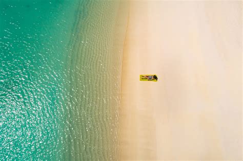 세이셸의 투명한 청록색 바다에서 수영 매트리스에서 수영하는 슬림 한 여성의 공중 보기 소녀와 여름 바다 풍경 아름다운 파도 다채로운 물 드론에서 보기 건강한 생활방식에 대한
